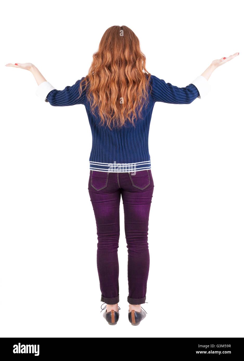 Back view of Beautiful woman looking at wall and Holds a hand up. Rear ...