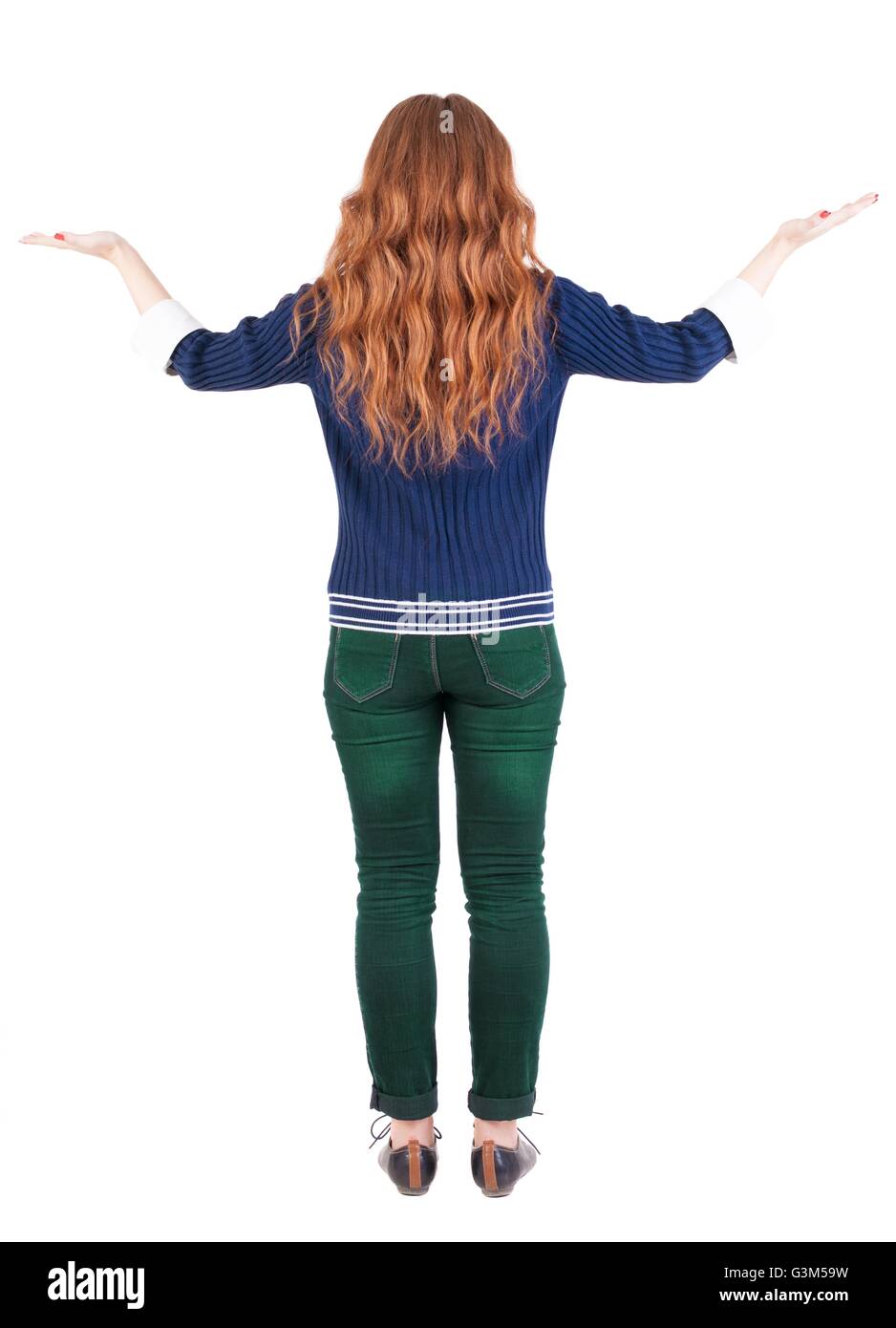 Back view of Beautiful woman looking at wall and Holds a hand up. Rear ...