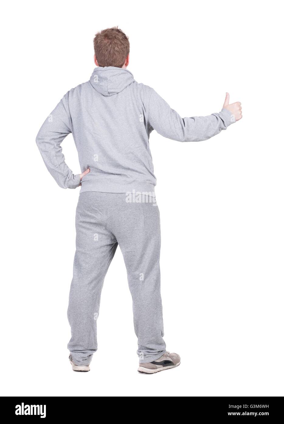 Back view of athlete man in gray tracksuit. shows thumbs up. Rear view ...