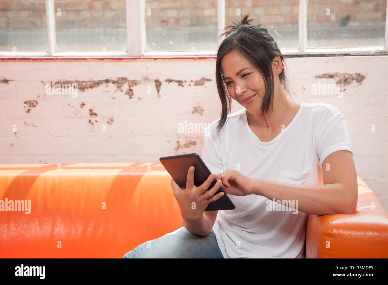 woman sitting on a sofa using an ipad Stock Photo - Alamy