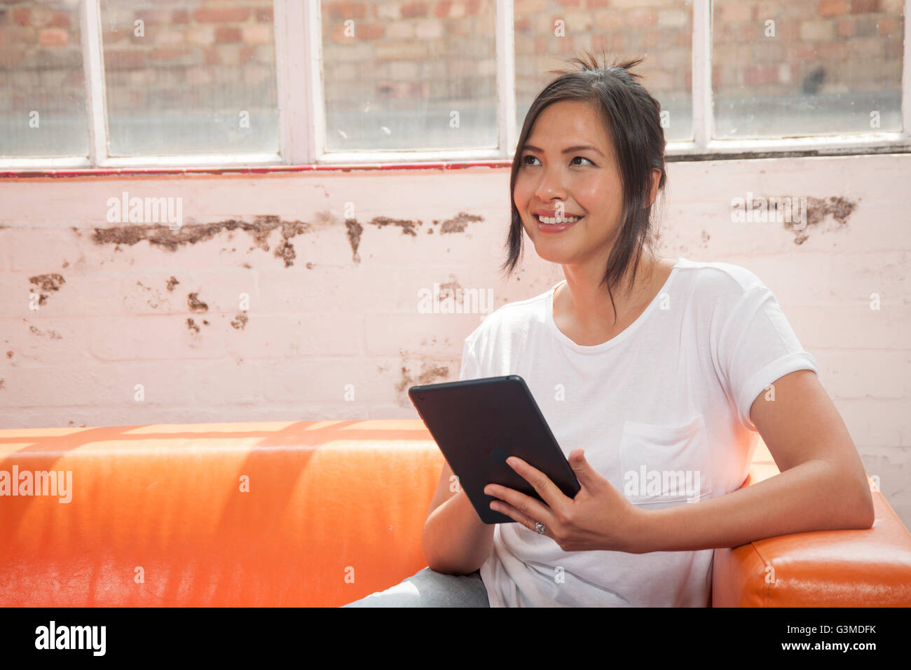 woman sitting on a sofa using an ipad Stock Photo - Alamy