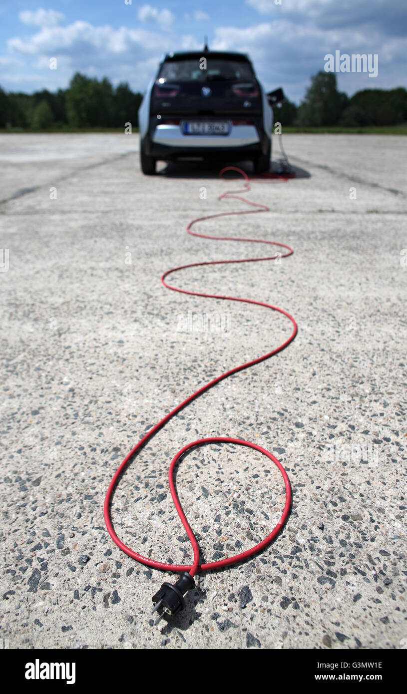 Symbolic image - A red electric cable behind a BMW i3 electric car on a ...