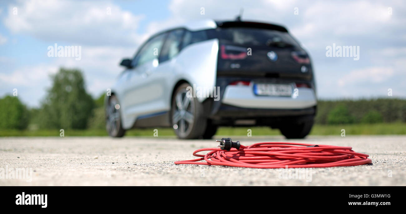 Symbolic image - A red electric cable behind a BMW i3 electric car on a ...