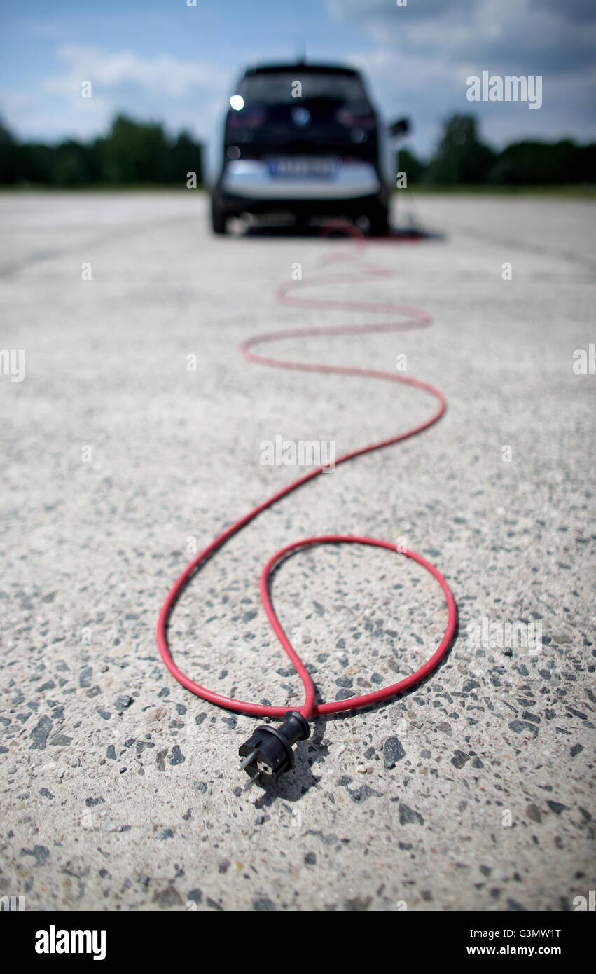 Symbolic image - A red electric cable behind a BMW i3 electric car on a ...