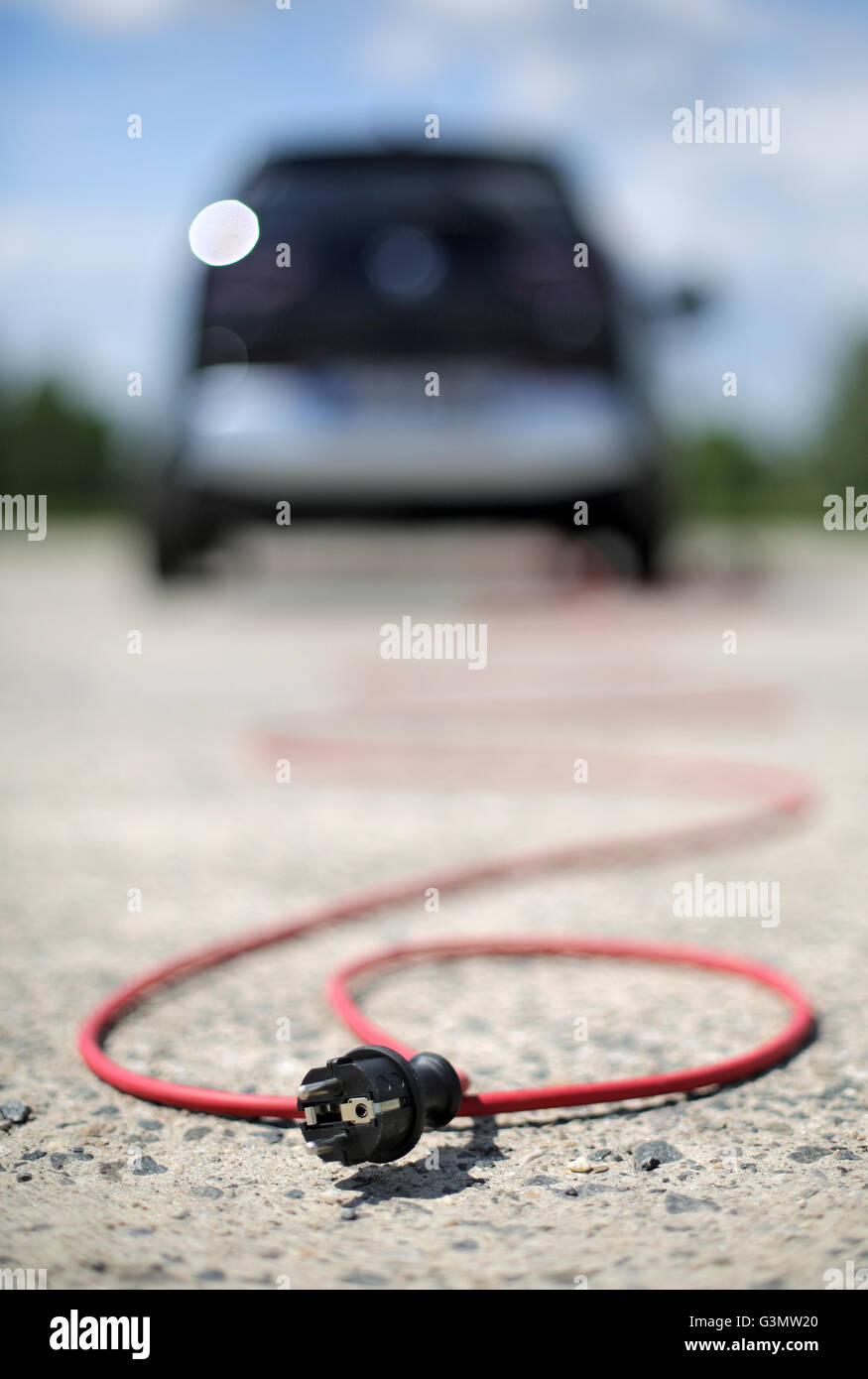 Symbolic image - A red electric cable behind a BMW i3 electric car on a ...