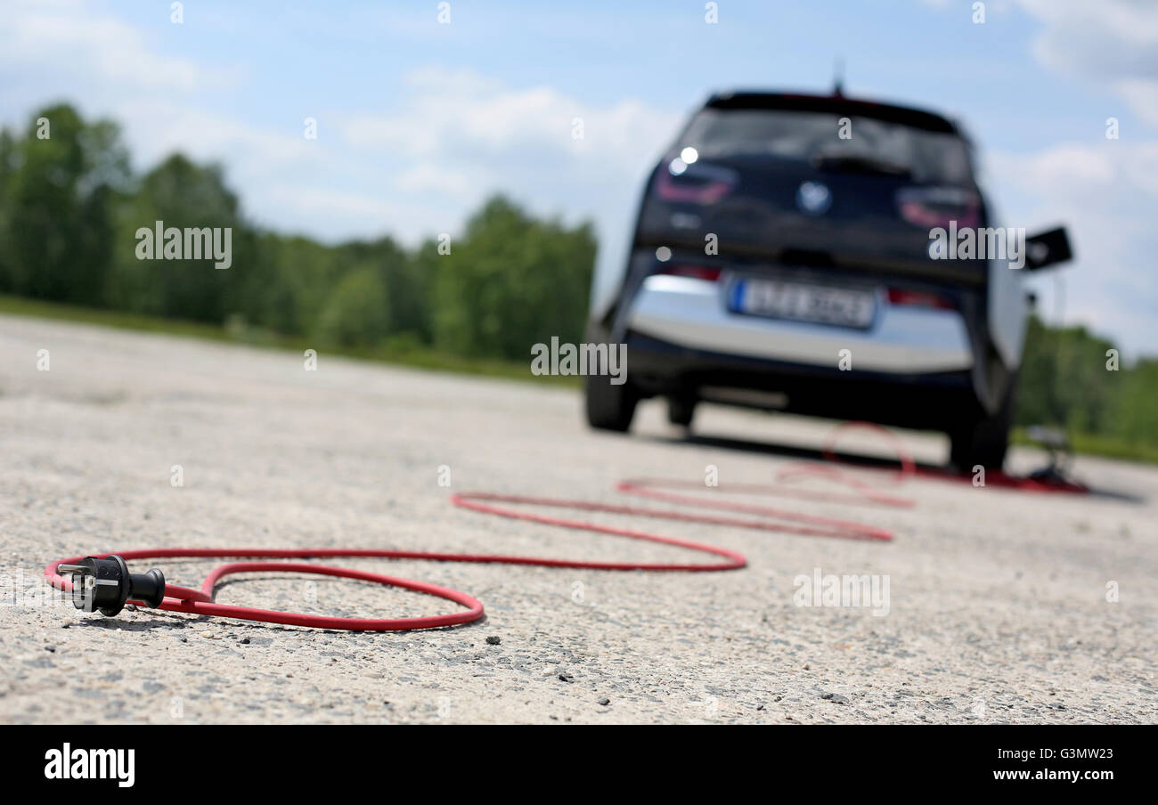 Symbolic image - A red electric cable behind a BMW i3 electric car on a ...