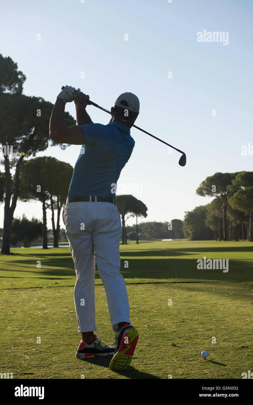golf player hitting shot with club on course at beautiful morning with ...