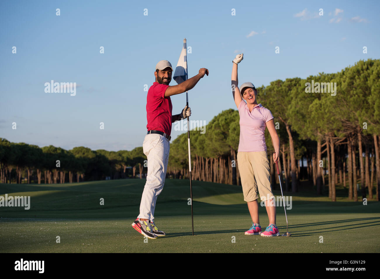 male golf instructor teaching female golf player, personal trainer ...