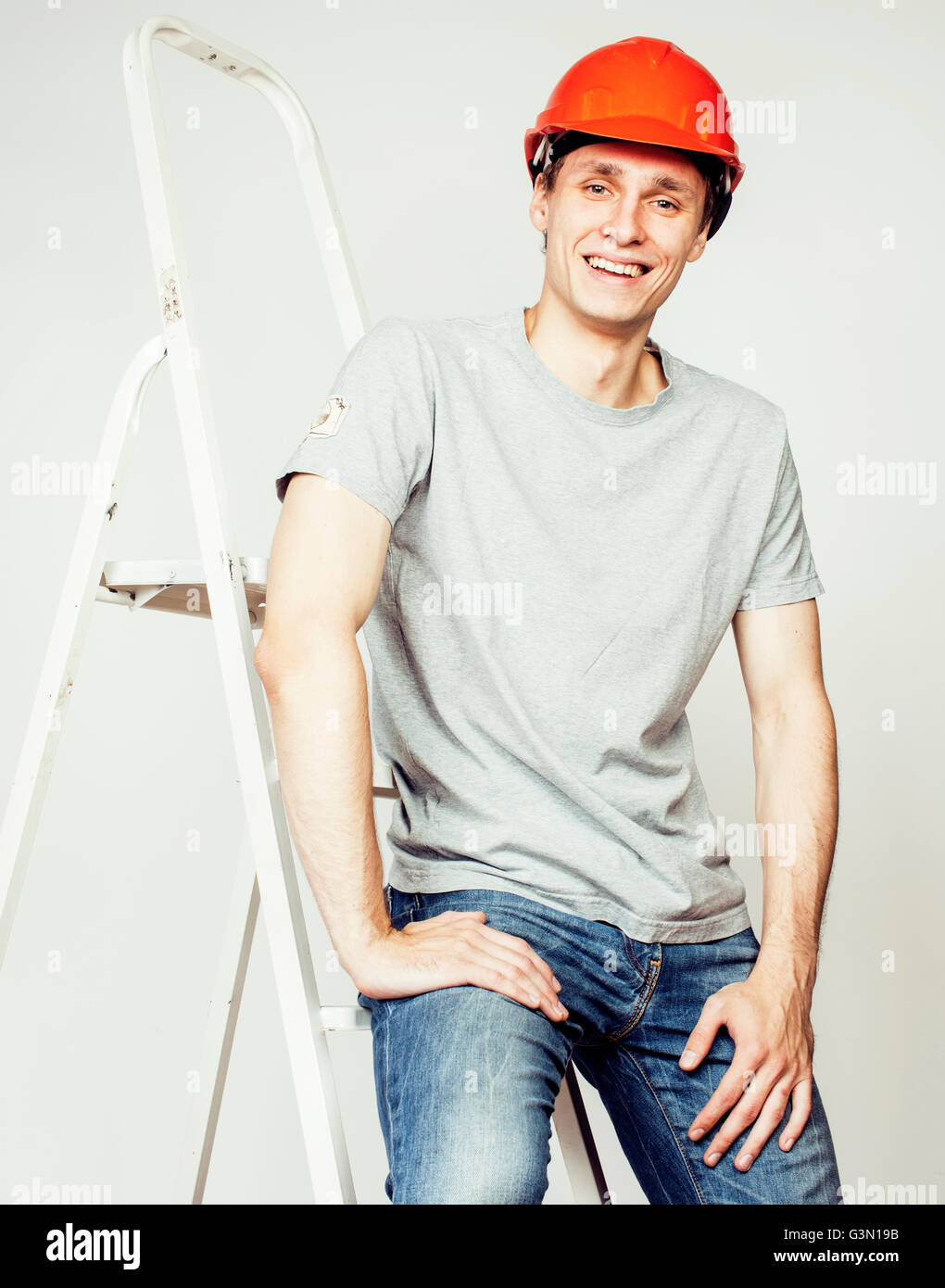 young real hard worker man isolated on white background ladder smiling ...