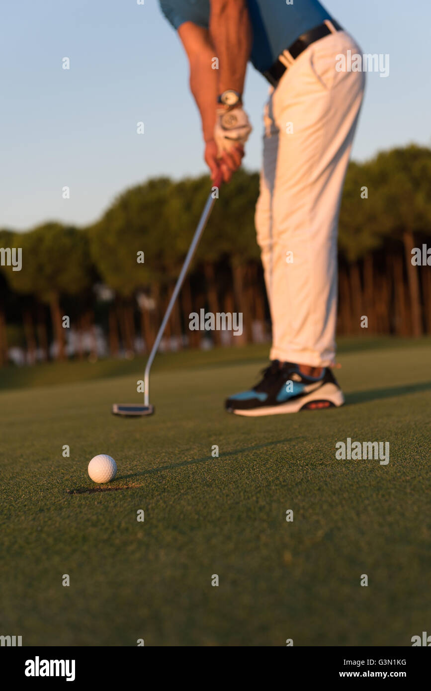 golfer hitting ball shot with driver on golf course at beautiful sunset ...