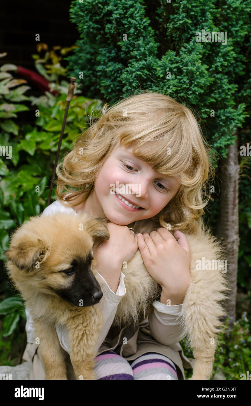 beautiful blond girl and cute baby dog Stock Photo - Alamy
