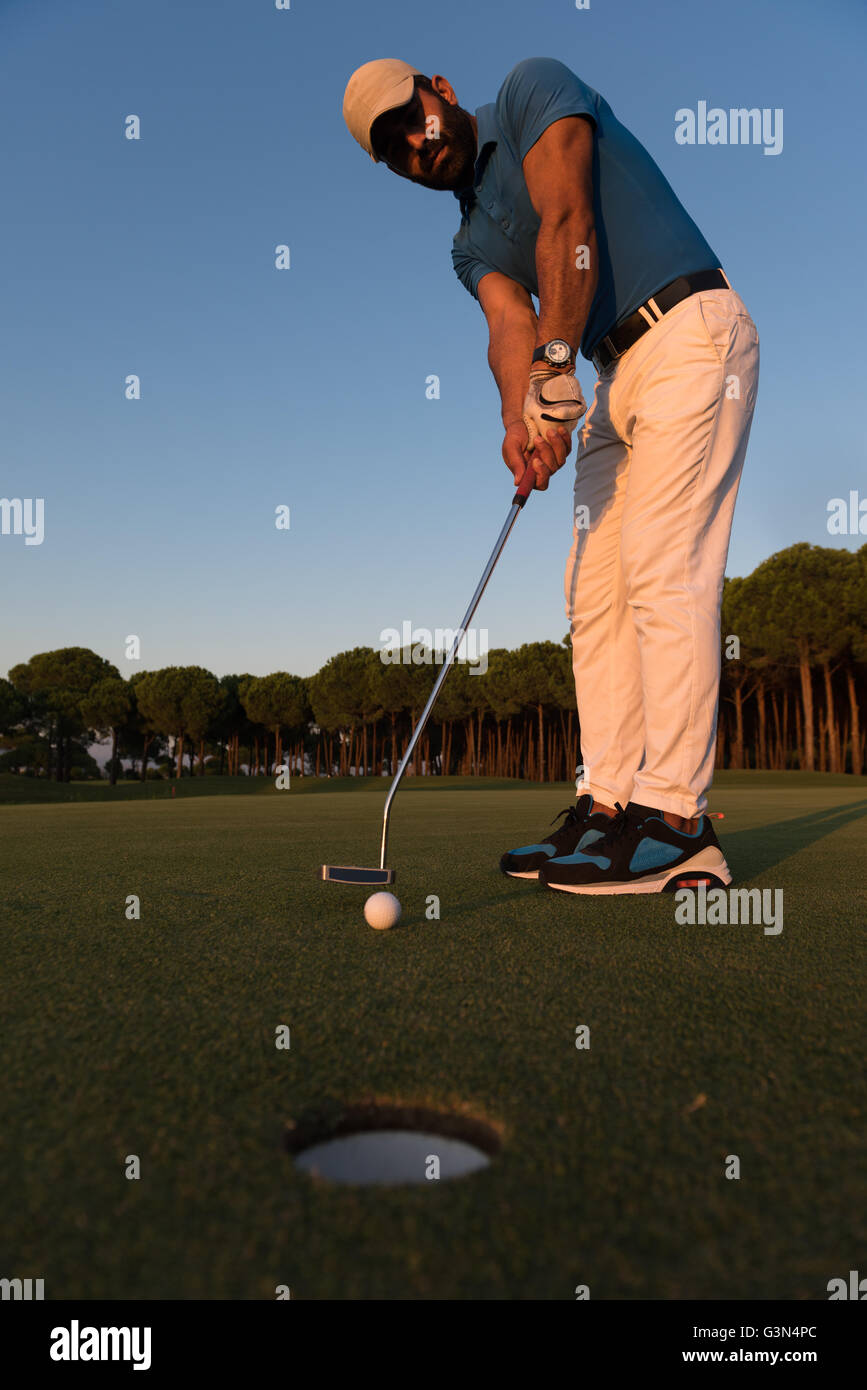 golfer hitting ball shot with driver on golf course at beautiful sunset ...