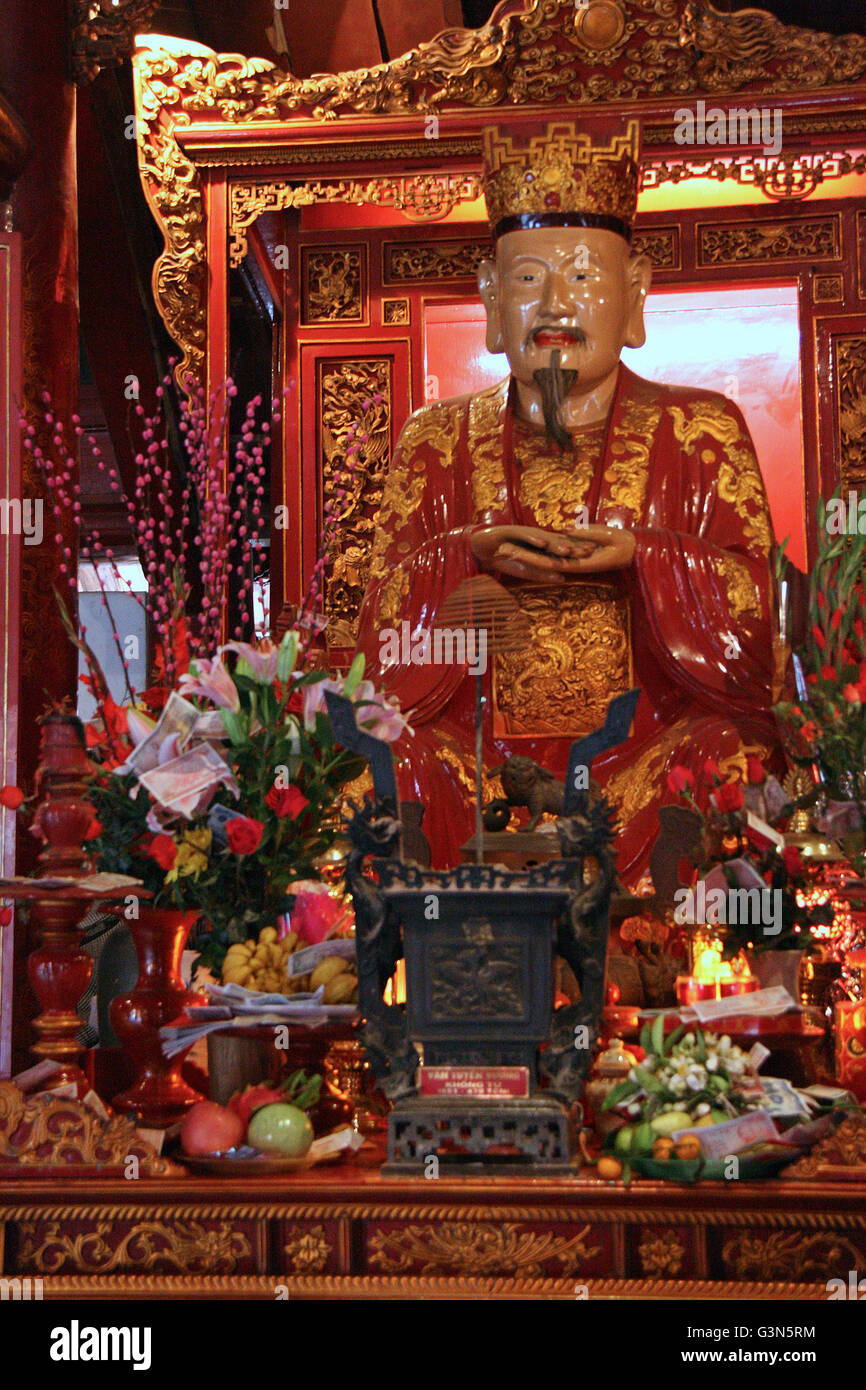 Statue of a divinity and offerings on an altar in the temple of ...
