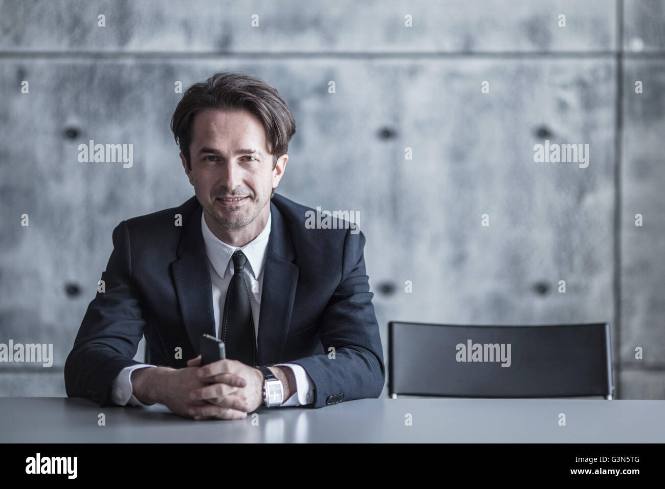 Man suit sitting behind table hi-res stock photography and images - Alamy