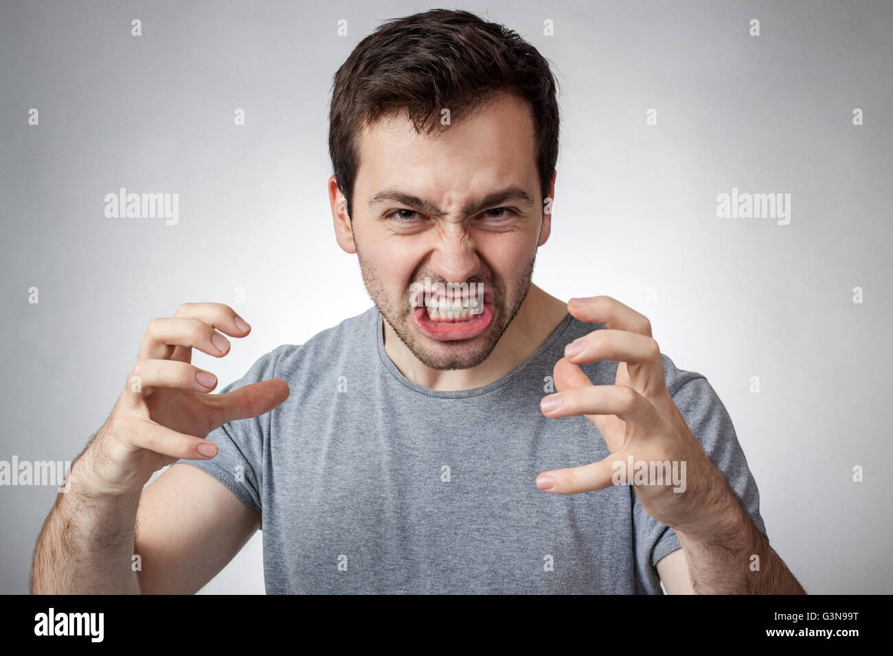 Angry young man clenching his teeth ready to pounce Stock Photo - Alamy