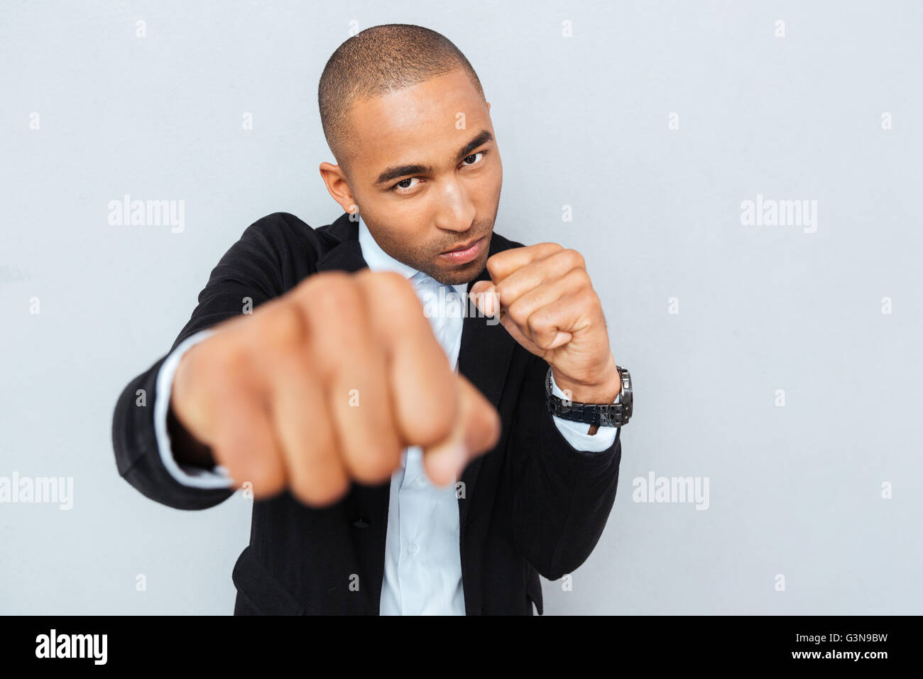 Angry young businessman standing in boxer position and ready to fight ...
