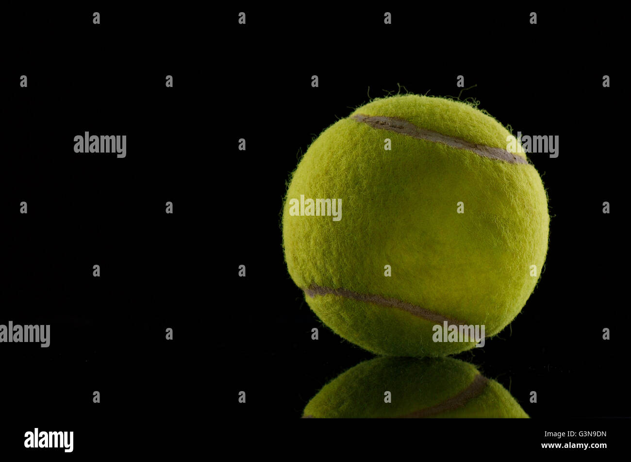 Single tennis ball isolated on black background Stock Photo - Alamy