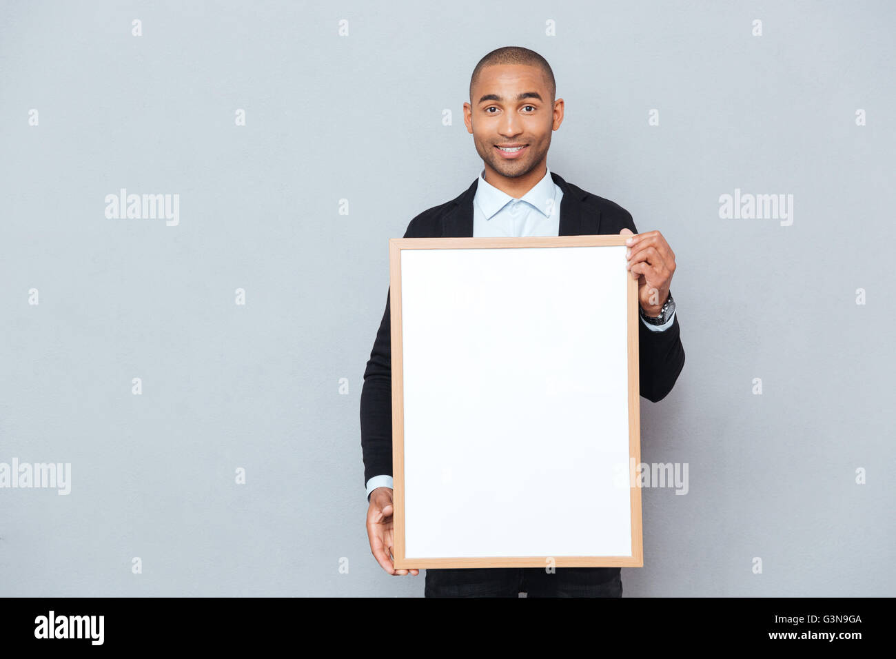 Cheerful attractive african man standing and holding whiteboard Stock ...