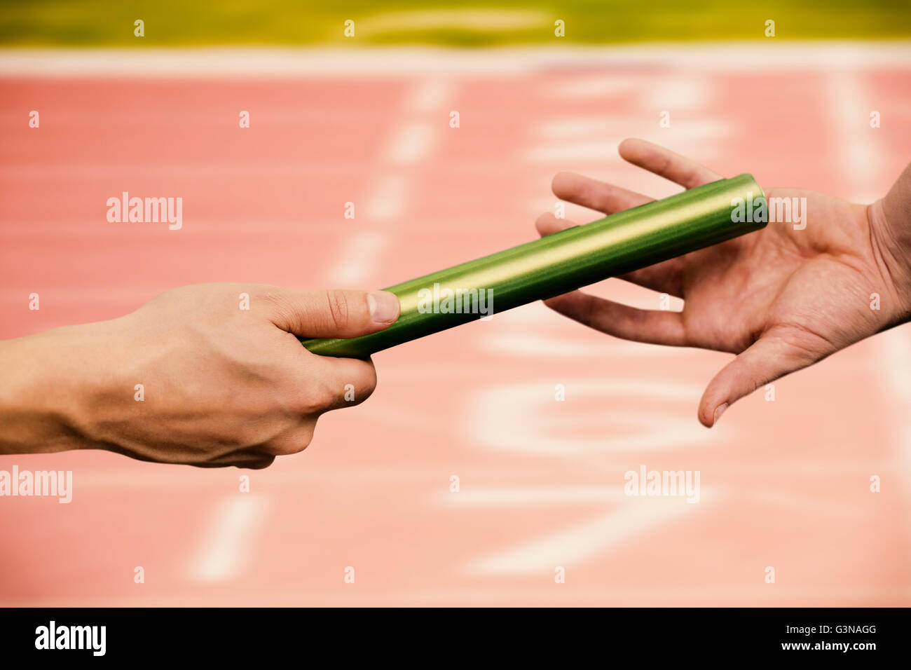 Composite image of man passing the baton to partner on track Stock ...