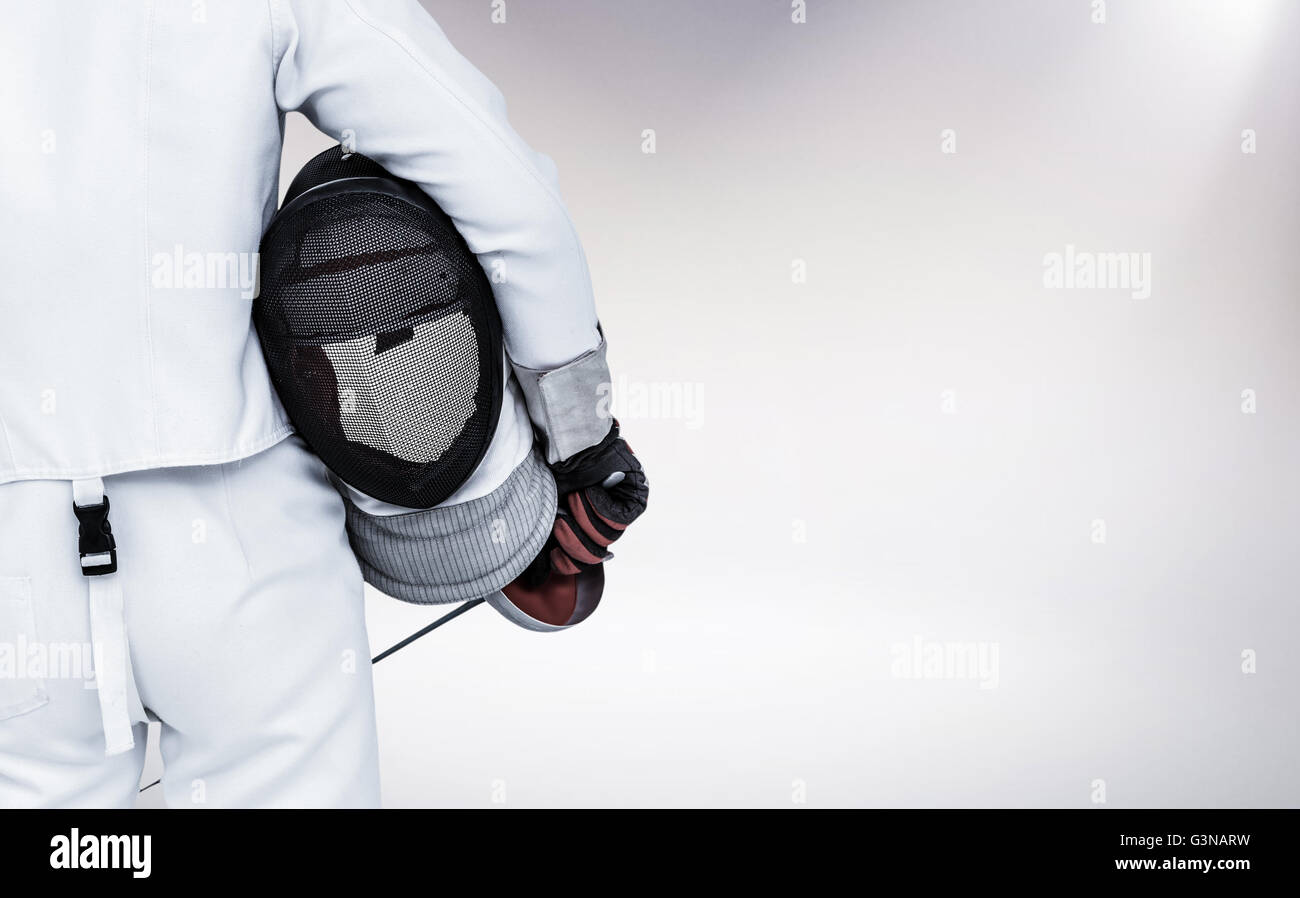 Composite image of rear view of swordsman holding fencing mask and ...