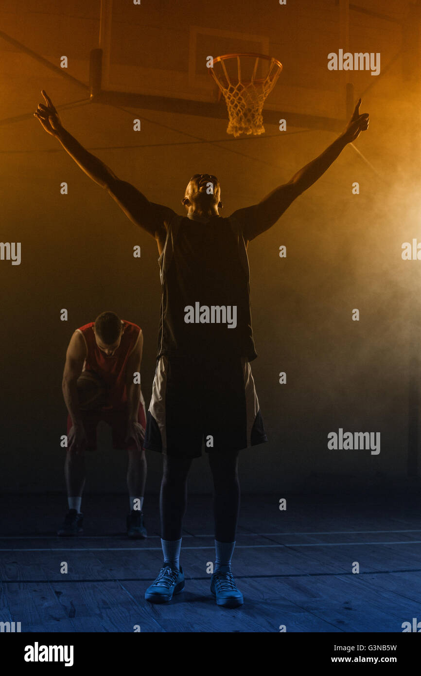 Victorious basketball player raising his arms up Stock Photo - Alamy
