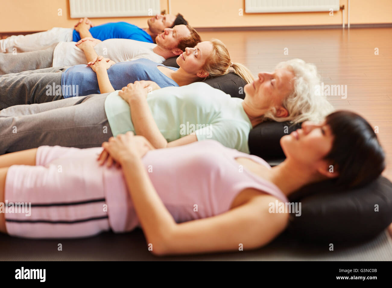 Senior and group during breathing exercise for relaxation at yoga class ...
