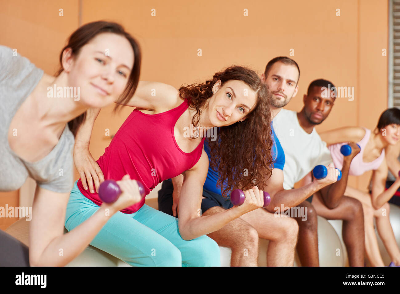 Group training with weights at fitness studio Stock Photo - Alamy