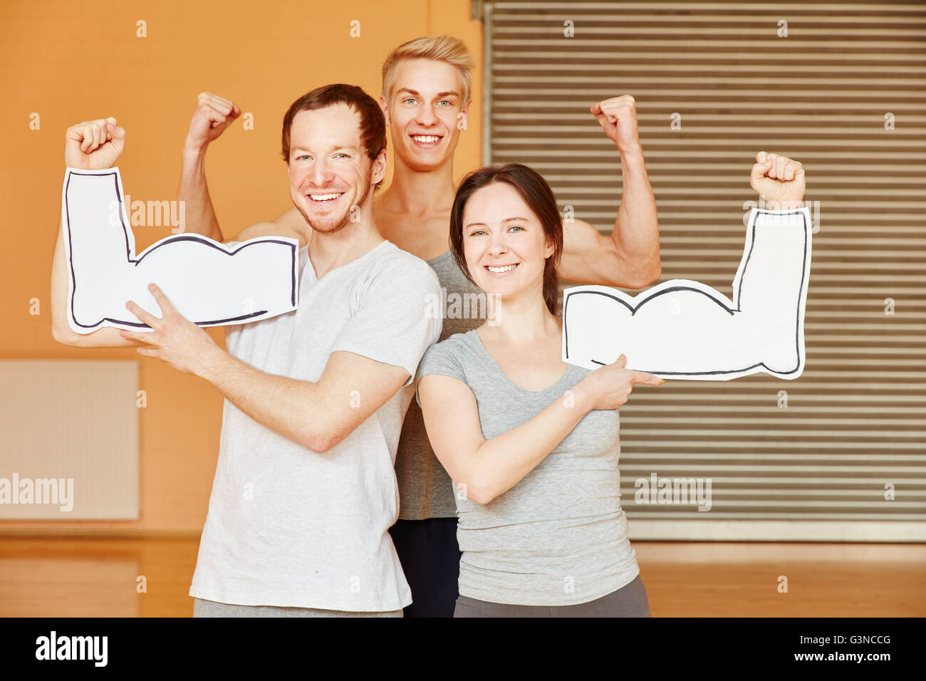 Successful friends showing muscles at fitness studio Stock Photo - Alamy