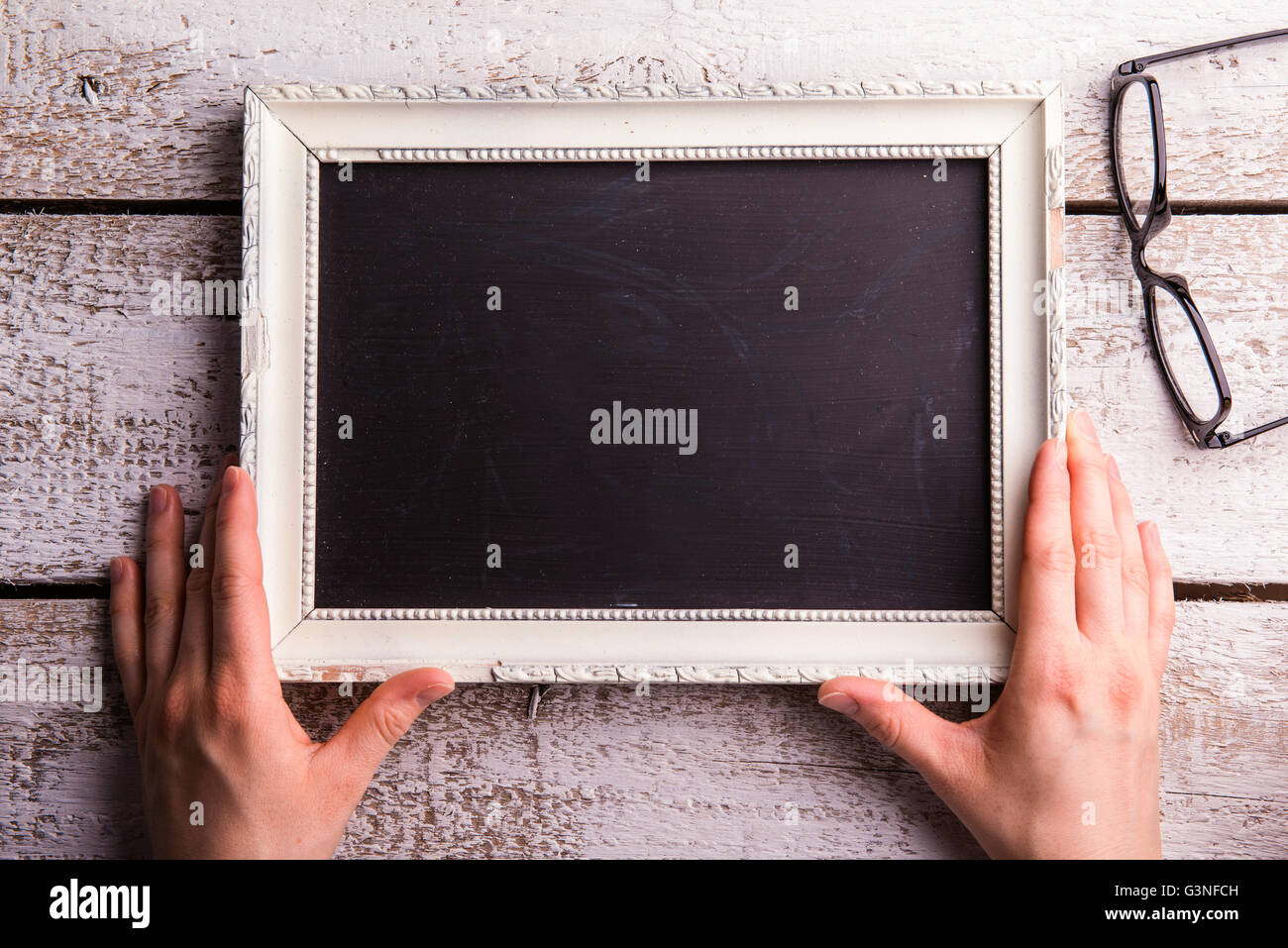 Unrecognizable woman holding empty picture frame, eyeglasses. St Stock ...