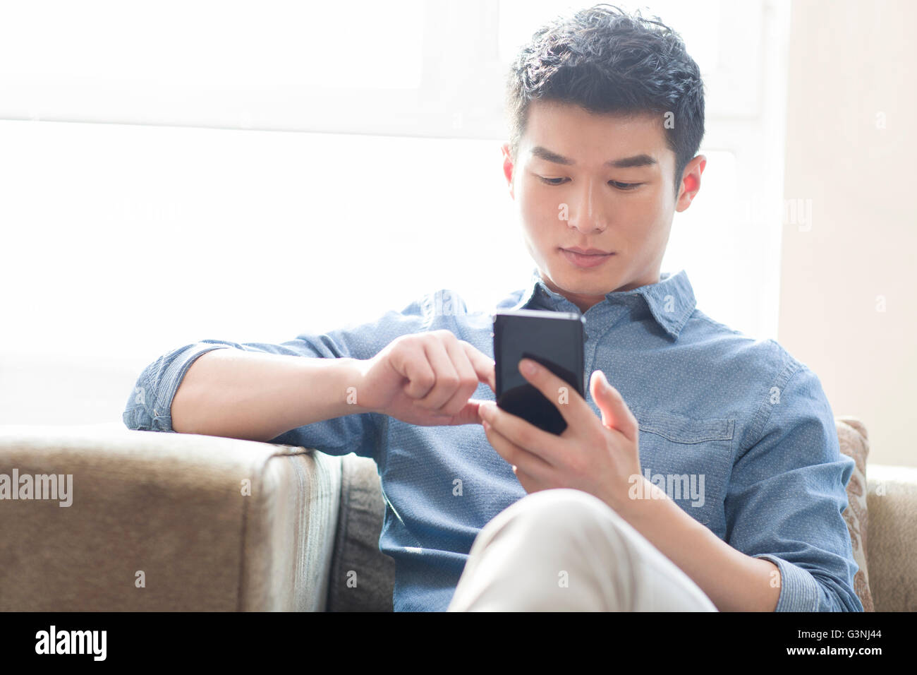 Young man using smart phone Stock Photo - Alamy