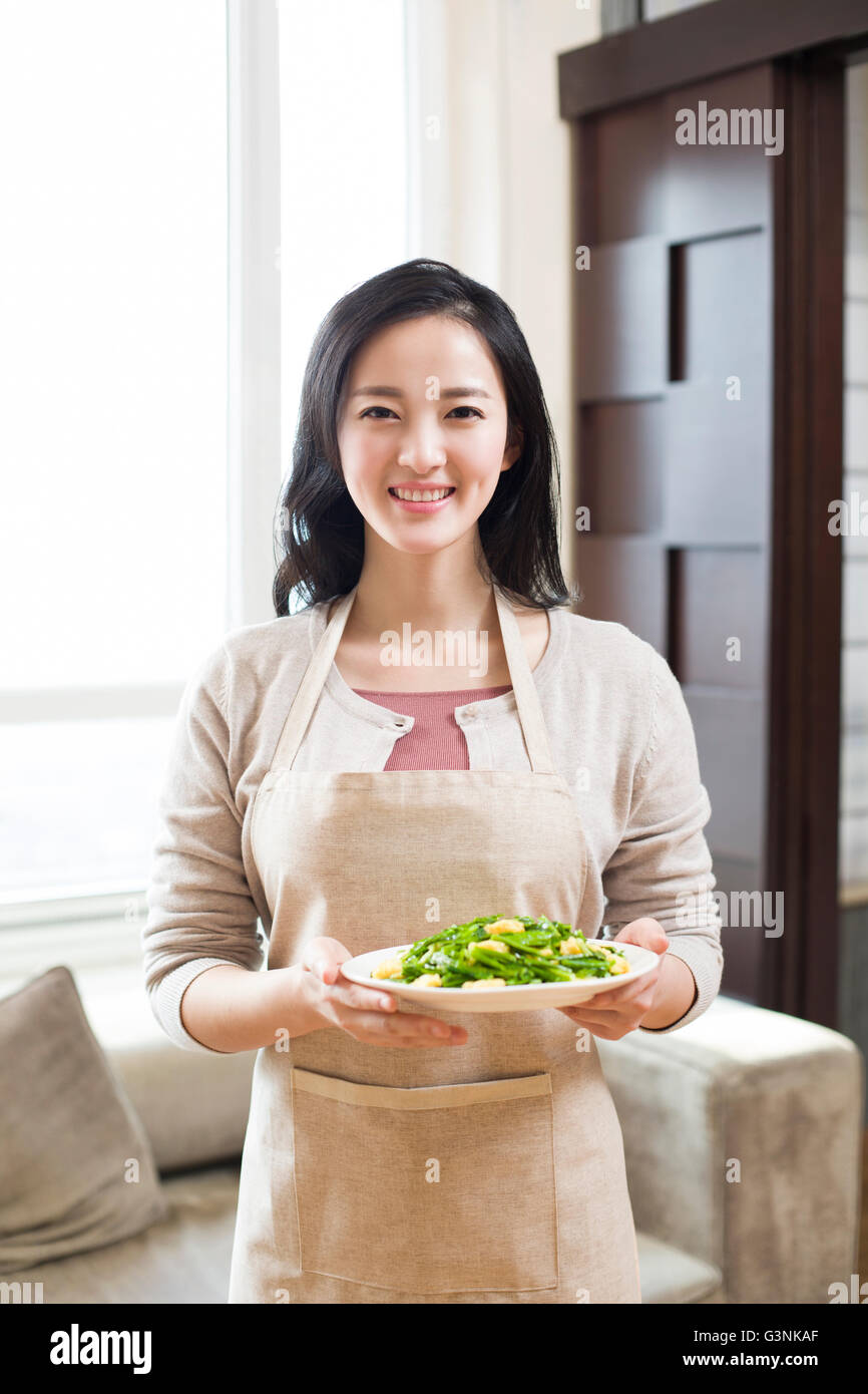 Happy young woman serving food Stock Photo - Alamy