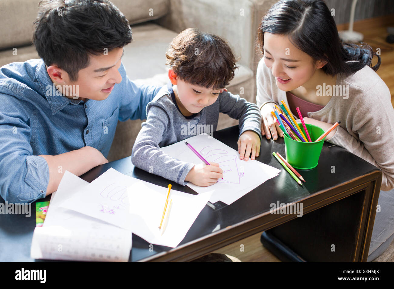 Young parents helping son with homework Stock Photo - Alamy