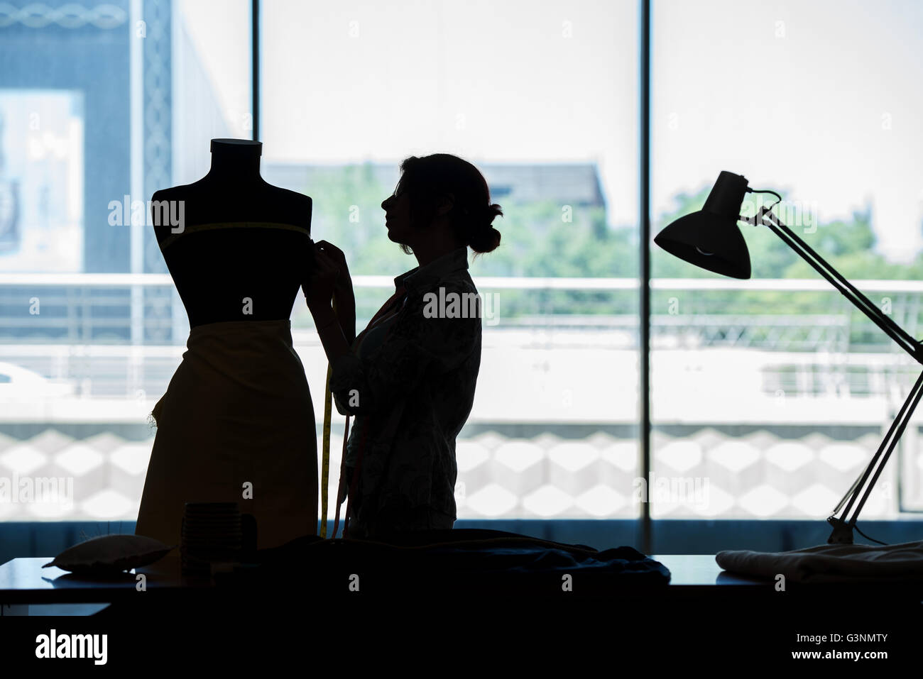 Woman tailor working at her desk Stock Photo - Alamy
