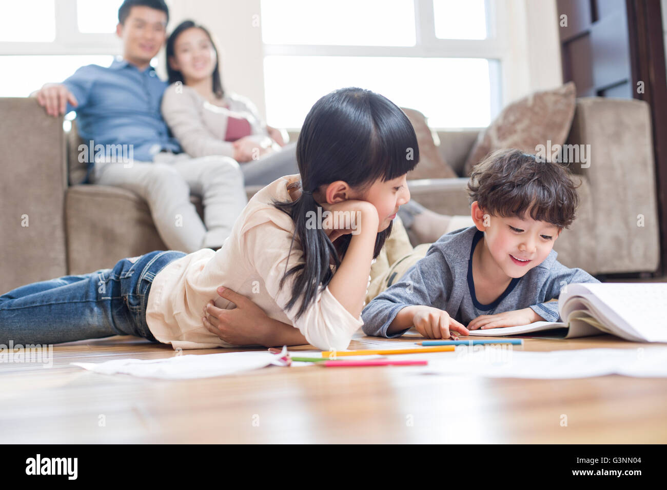 Happy siblings studying together at home Stock Photo - Alamy