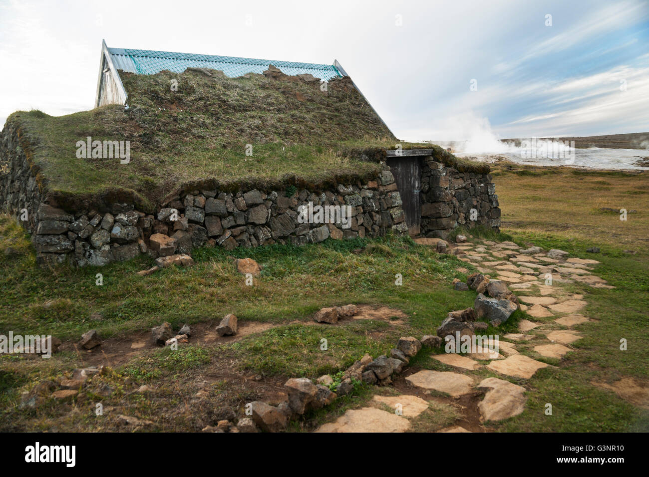 Sod roofed building with large rocks for a wall on a grassy plain on ...