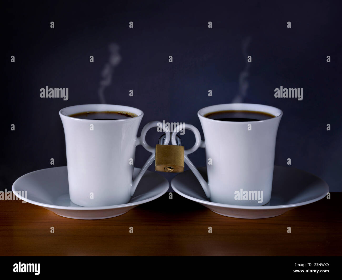 Two cups of coffee, together with a lock on black background Stock ...
