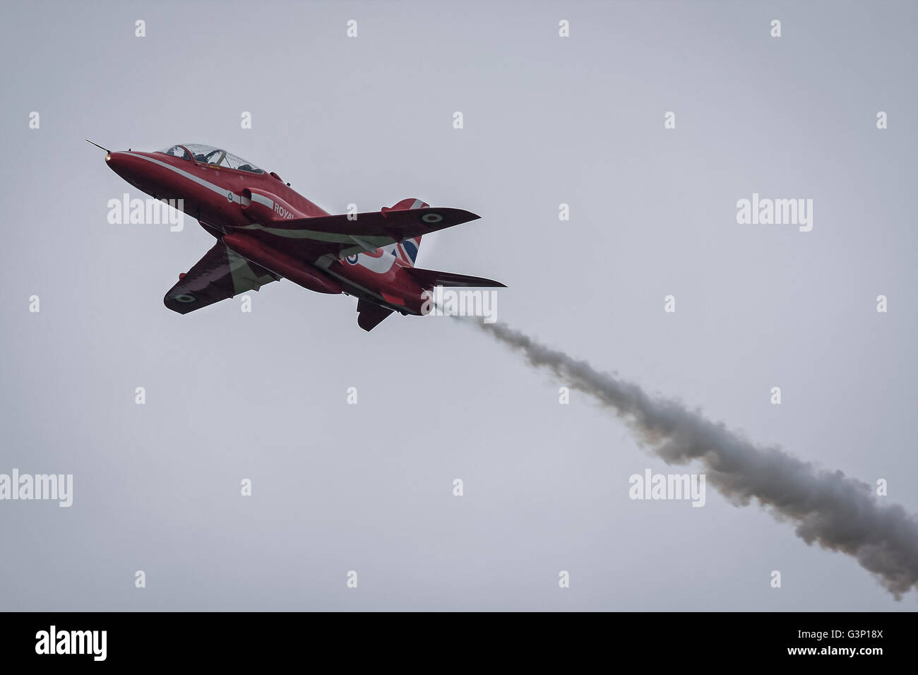 RAF Red Arrow Hawk jet in flight with white smoke being trailed as part ...