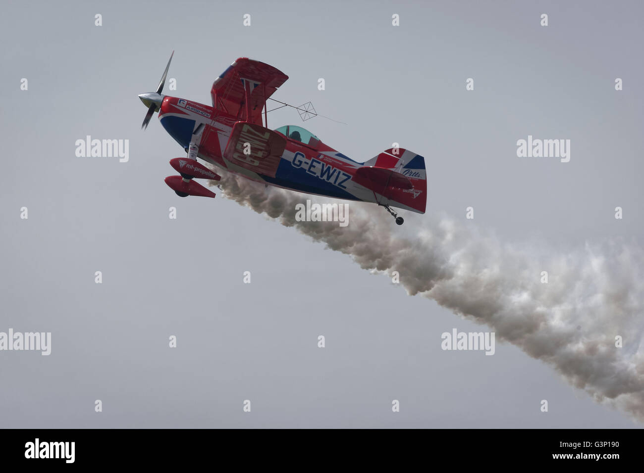 Pitts Special acrobatic plane in the sky with white smoke trails Stock ...