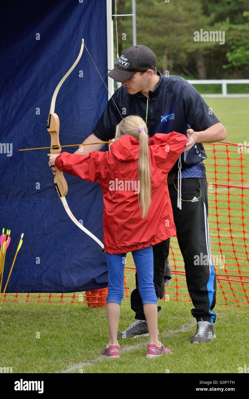 A young girl getting a lesson in archery in Glasgow, Scotland, UK Stock ...