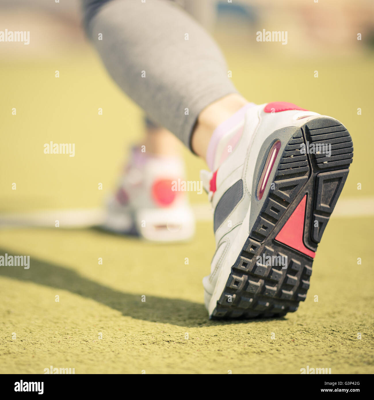 Sportswoman start running at the stadium. Female feet in trainers at ...