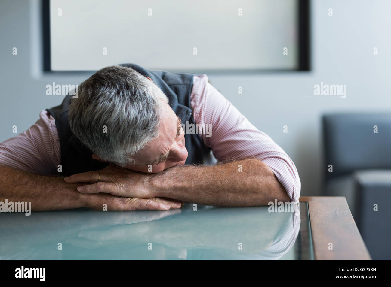 Senior man sleeping on table Stock Photo - Alamy