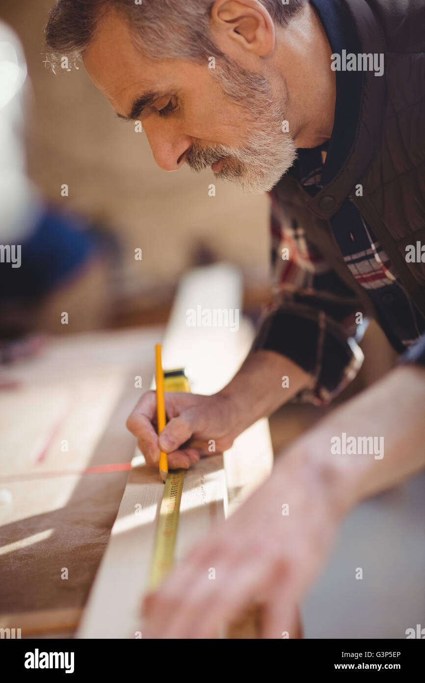 Carpenter marking on wooden plank with pencil Stock Photo - Alamy