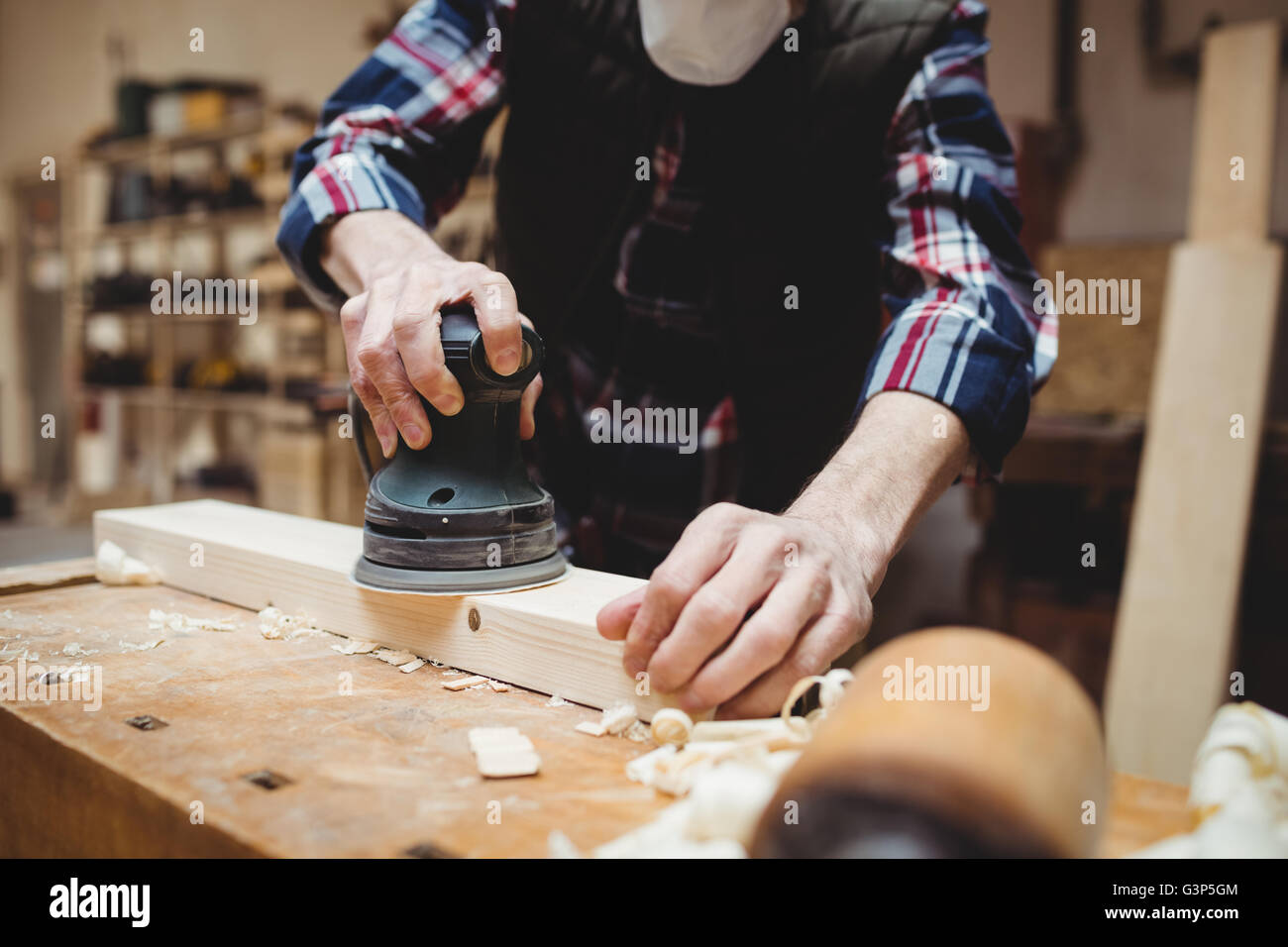 Carpenter sanding down a plank of wood Stock Photo - Alamy