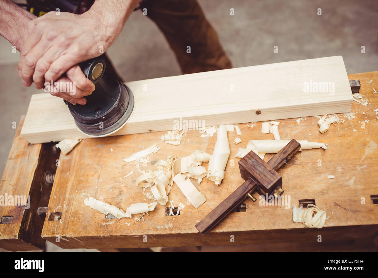 Carpenter sanding down a plank of wood Stock Photo - Alamy