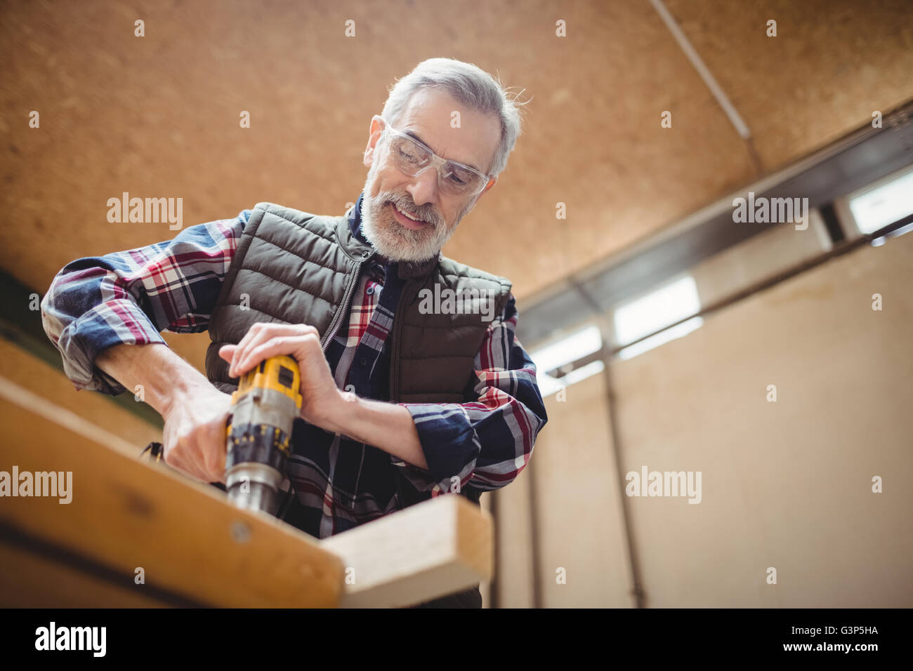 Carpenter drilling a plank of wood Stock Photo - Alamy