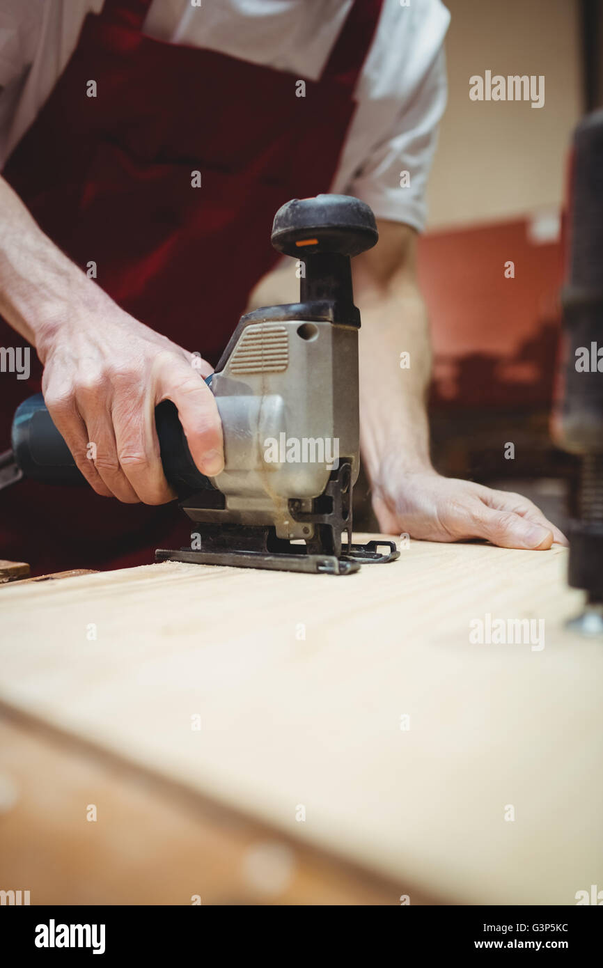 Carpenter cutting a plank of wood Stock Photo - Alamy