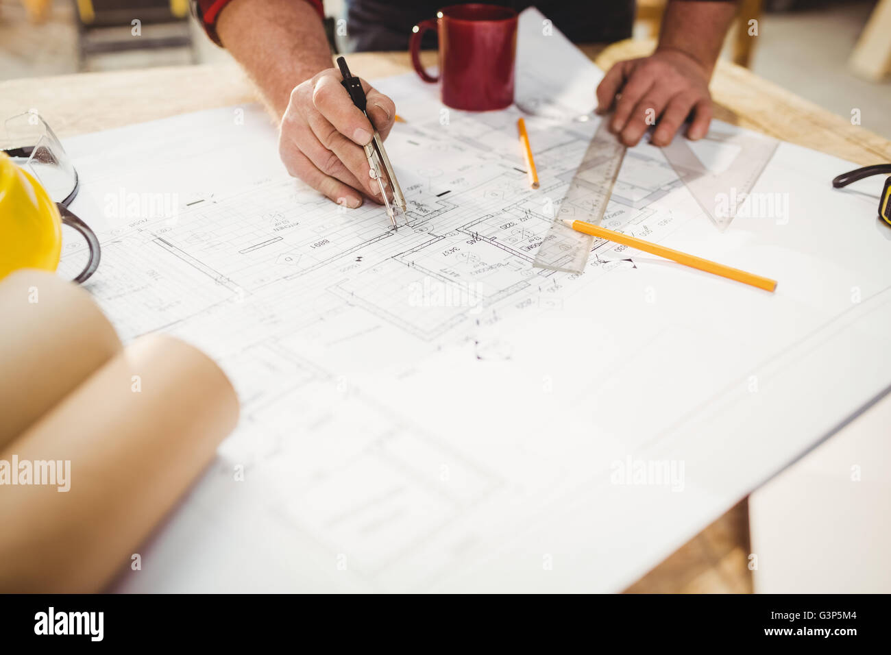 Carpenter drawing on a plan with a compass Stock Photo - Alamy