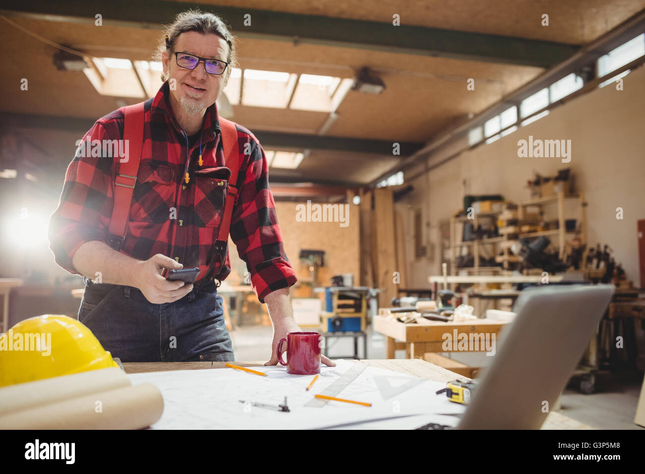 Carpenter using his smartphone Stock Photo - Alamy