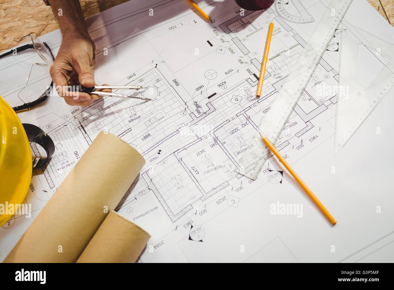 Carpenter drawing on a plan with a compass Stock Photo - Alamy
