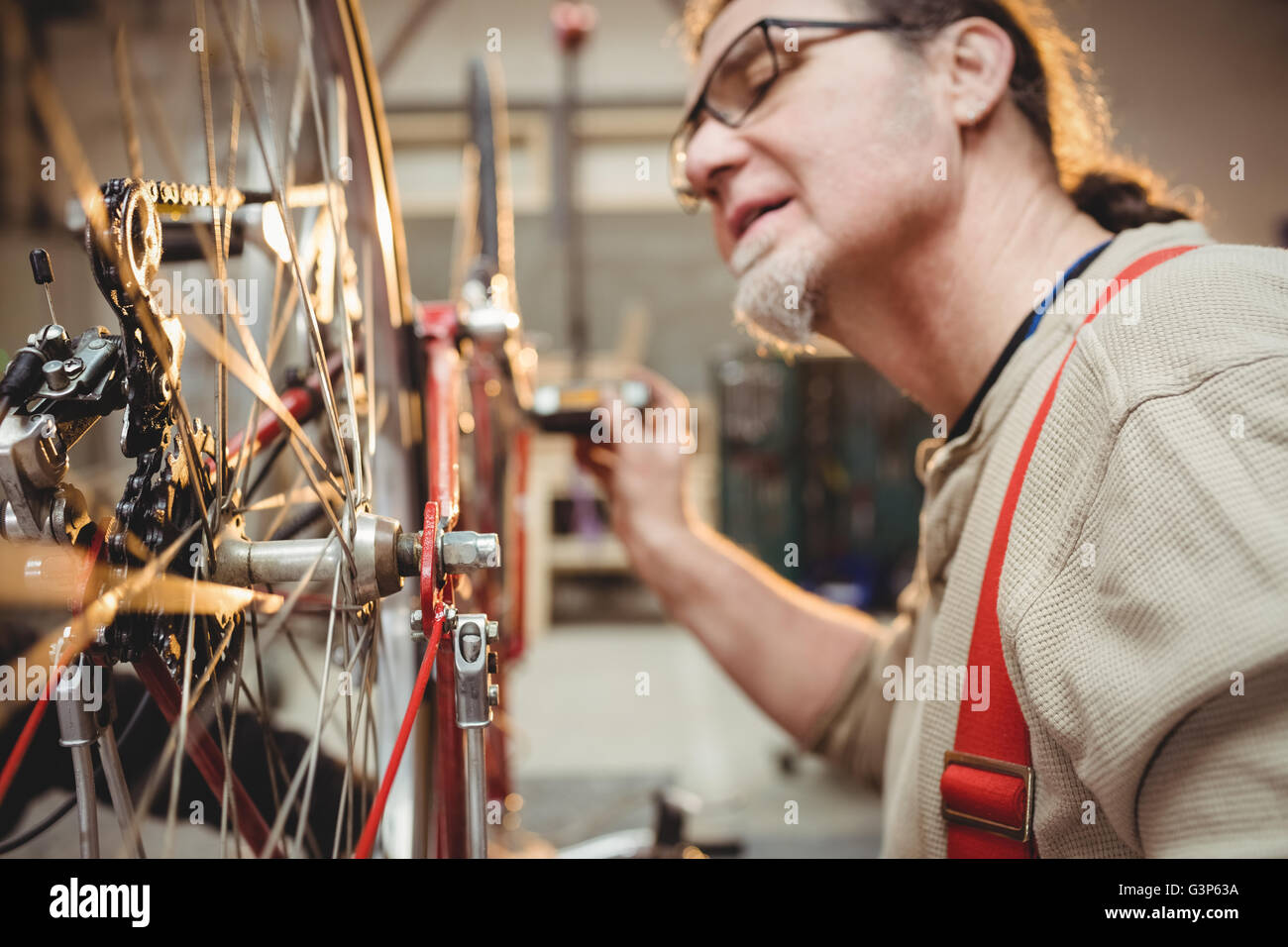 Bike mechanic repairing a bike Stock Photo - Alamy